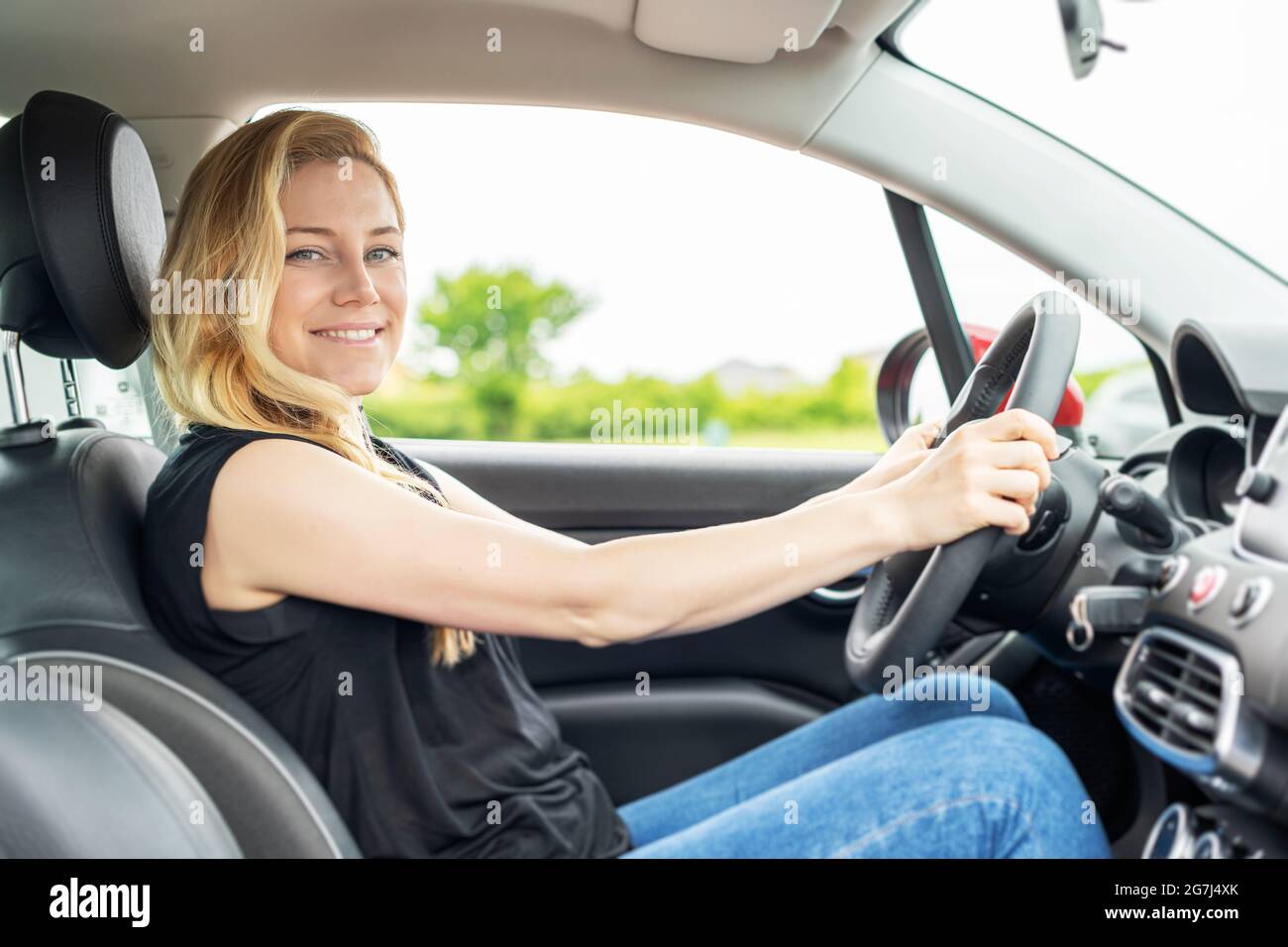 Happy beautiful woman drives a car Stock Photo - Alamy