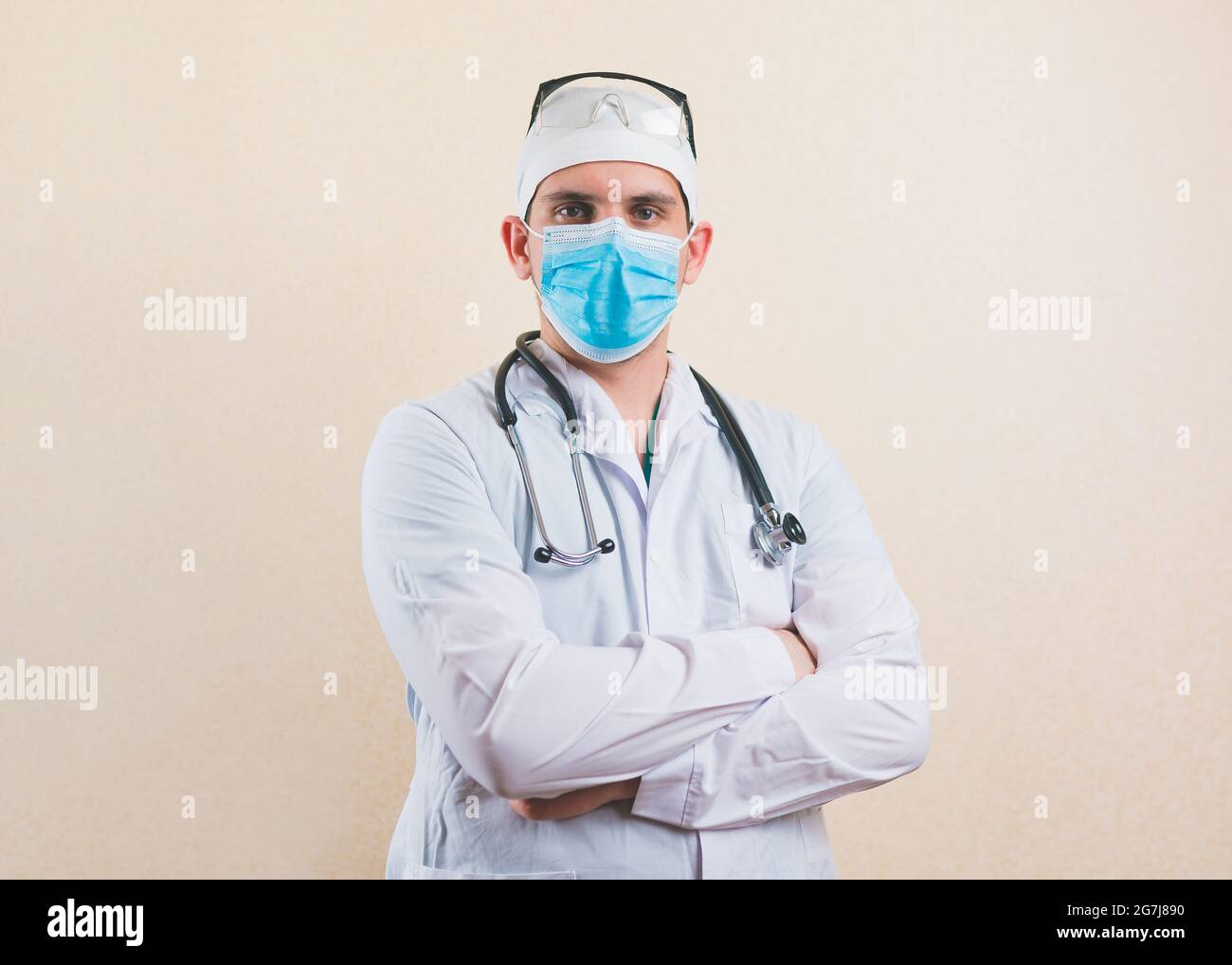 Young doctor in white suit, protective glasses, stethoscope and ...