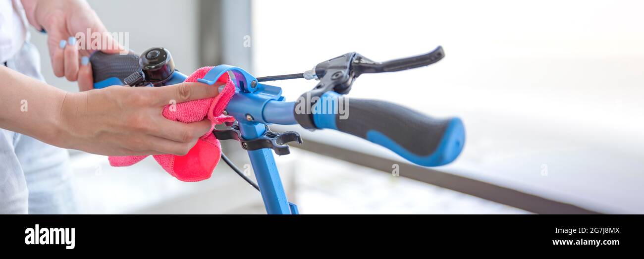 Cleaning or washing the scooter. Electric scooter care. A woman wipes a ...