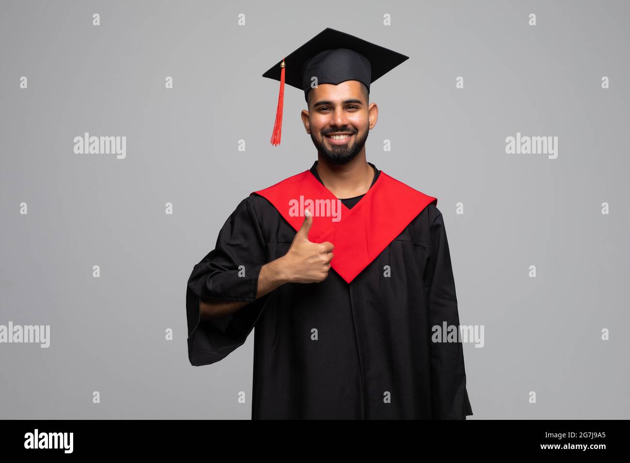 Asian Graduate man in cap and gown smile Celebrating showing thumbs up ...