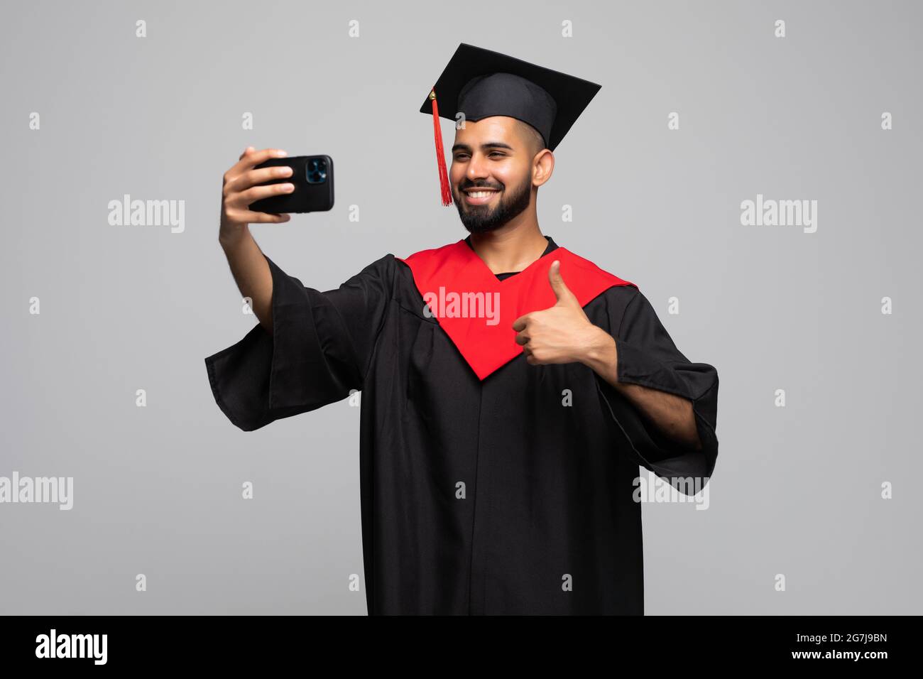 College graduate taking a selfie with cell phone holding a diploma ...
