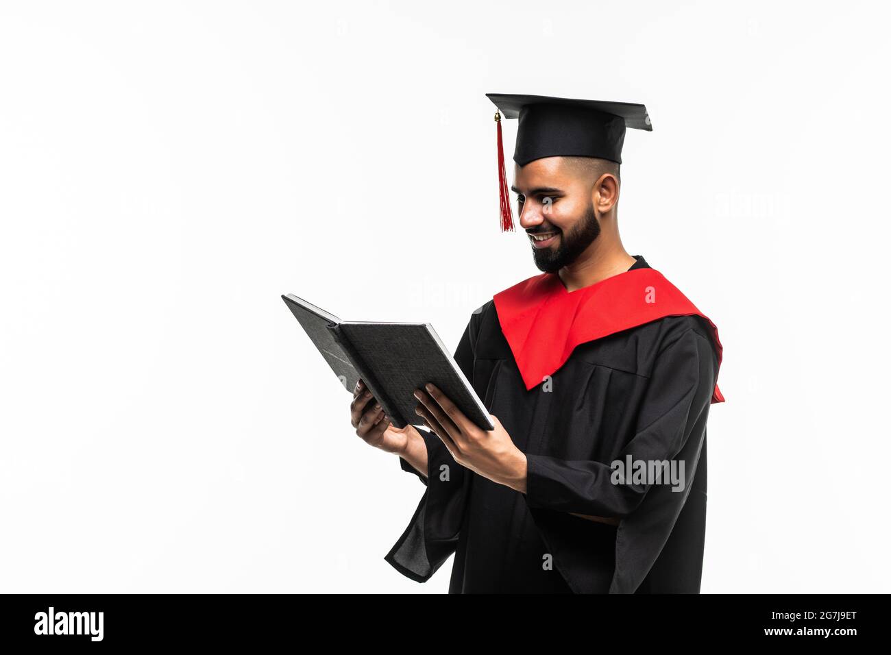 Smart young man in a graduation gown showing his academic books. Law or ...