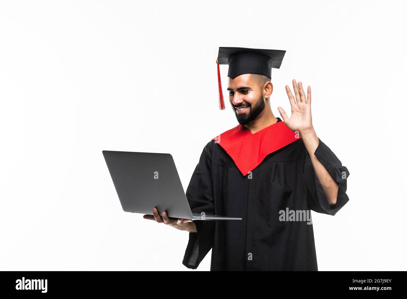 Male graduate holding a laptop computer and smiling at the camera ...
