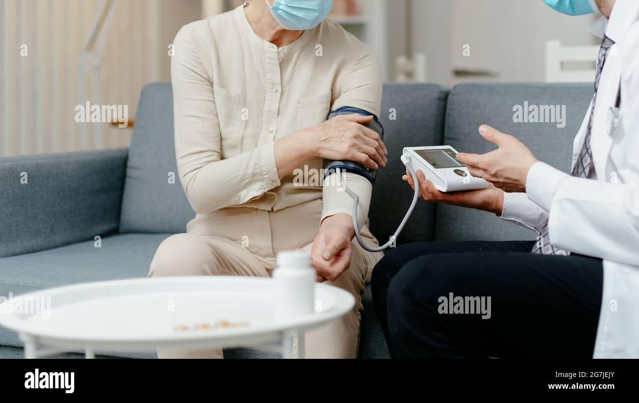 doctor is looking at the monitor of the blood pressure monitor during a ...