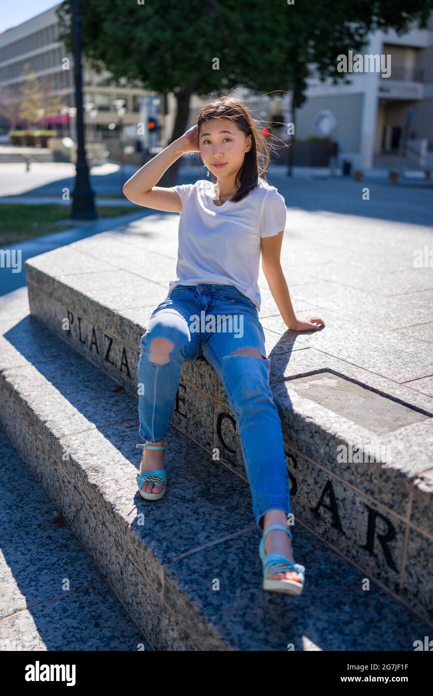 Young Asian Woman Seated on Steps in Downtown Plaza Stock Photo - Alamy
