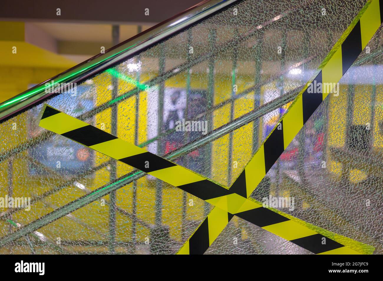 Broken glass window together with a yellow black warning sign tape are ...