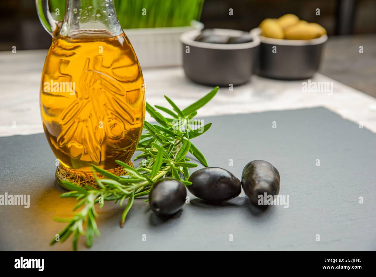 Olive oil. Olives on a background of olive oil. A bottle pours oil into ...