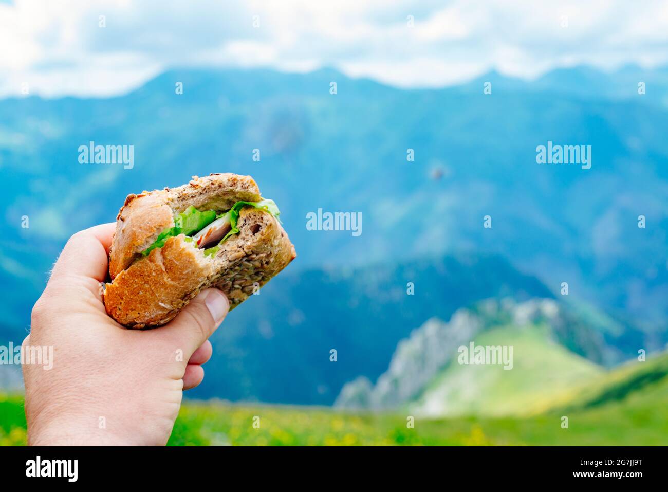 Man eating delicious sandwich on mountain on trail Stock Photo - Alamy