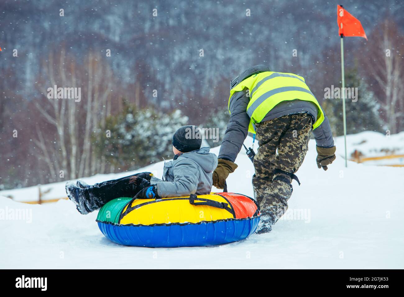 winter fun activities. ride down by hill on snow tubing. pushing Stock ...