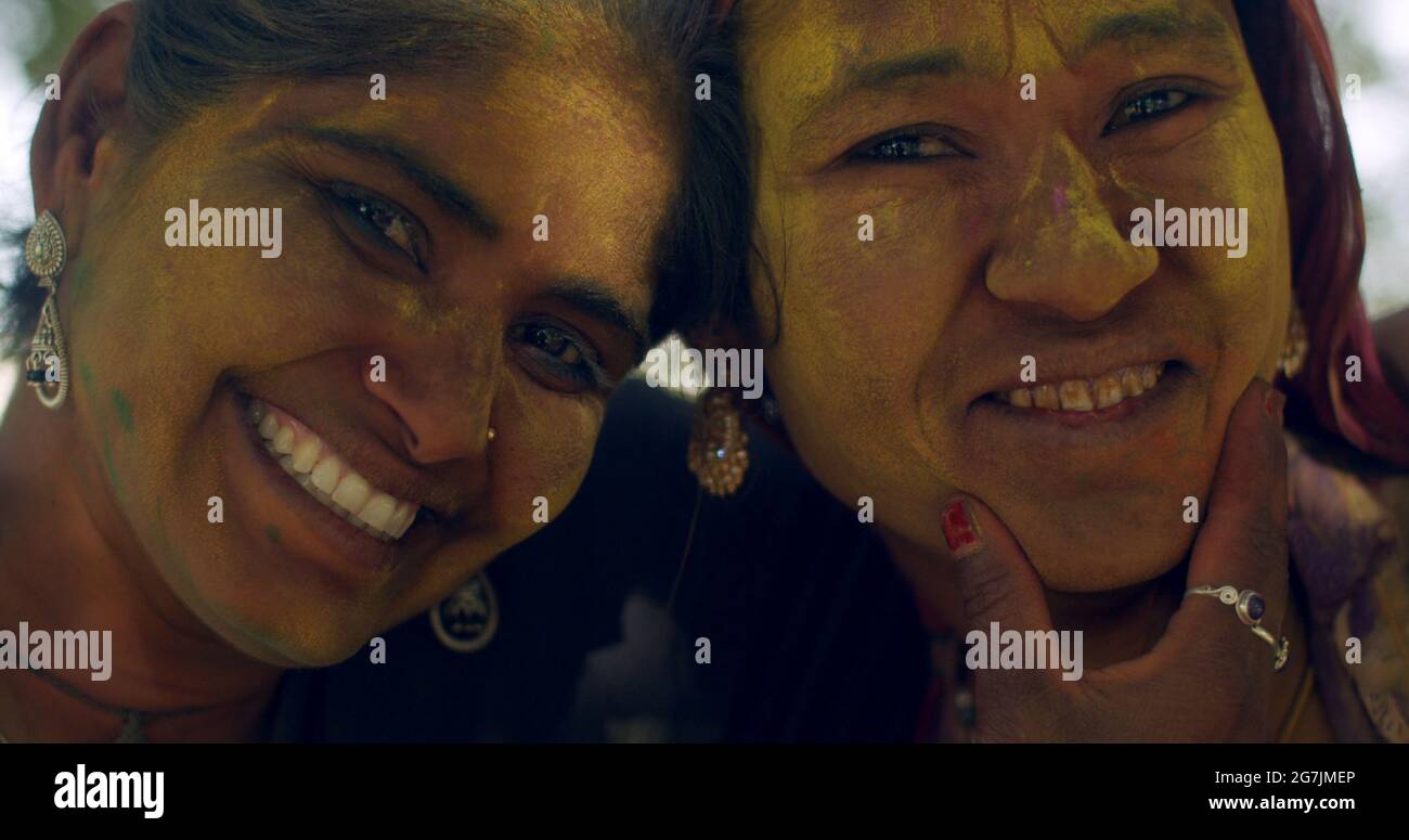 Closeup of beautiful smiling Indian women with colored faces during the ...
