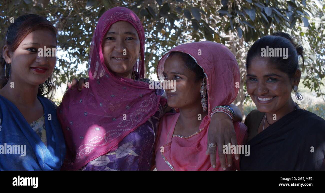 Closeup of pretty smiling Indian women in traditional saris standing in ...