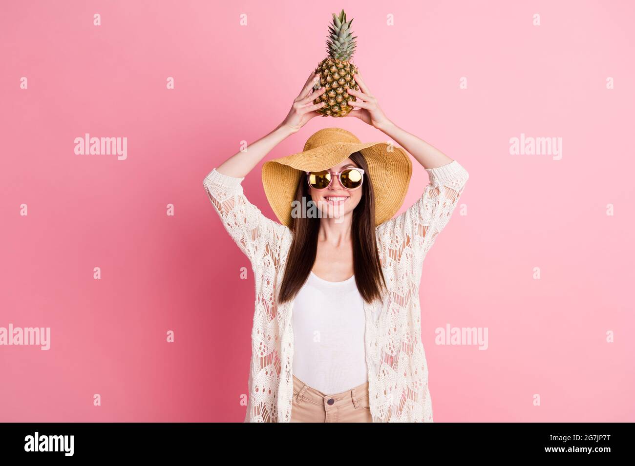 Portrait of adorable satisfied girl hands hold pineapple above head ...