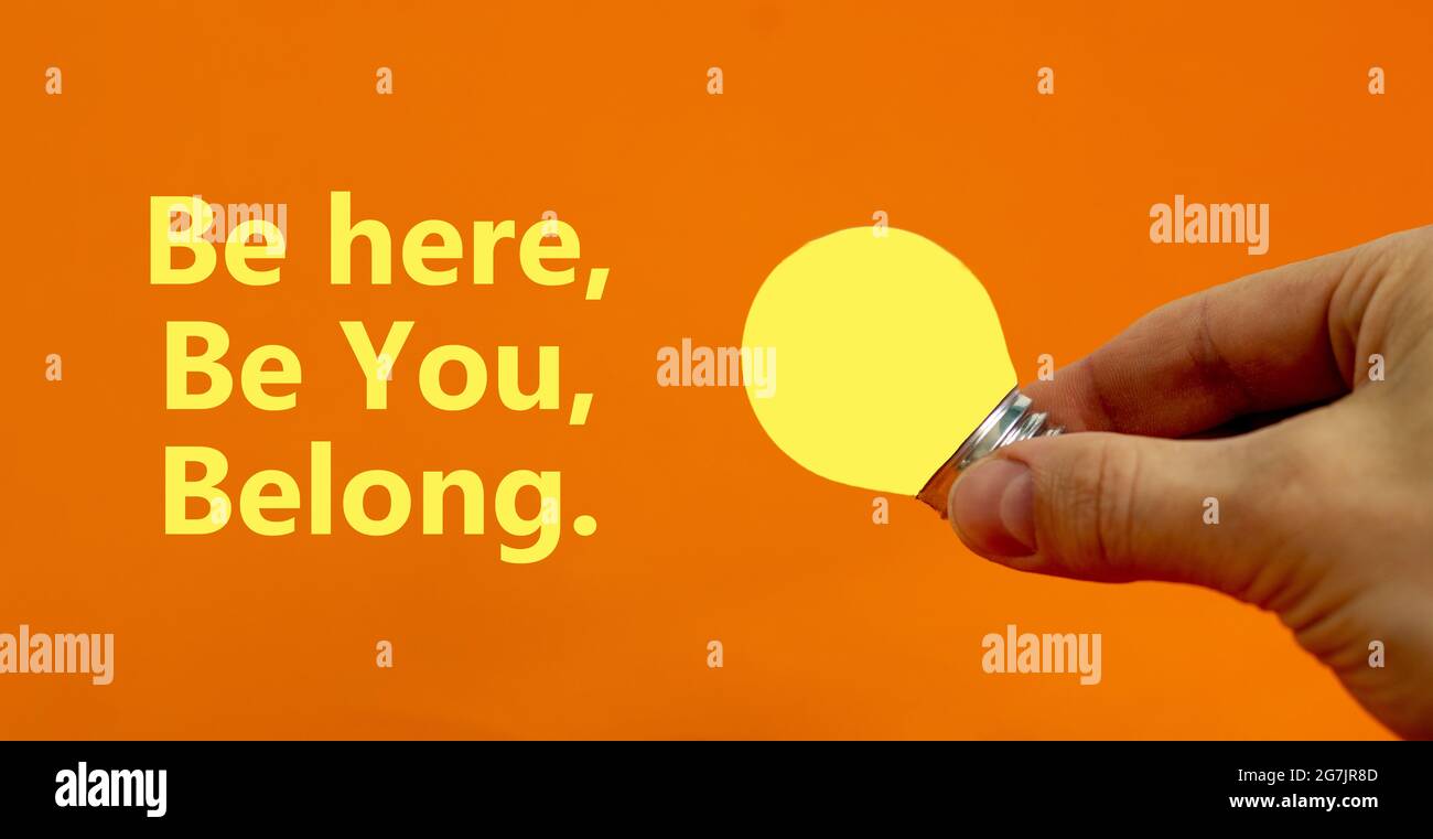 You belong here symbol. Businessman holds yellow shining light bulb ...