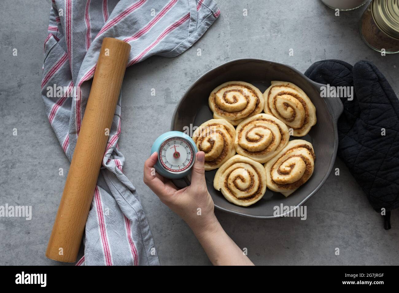 White woman holds an analog retro timer showing the time to bake for ...