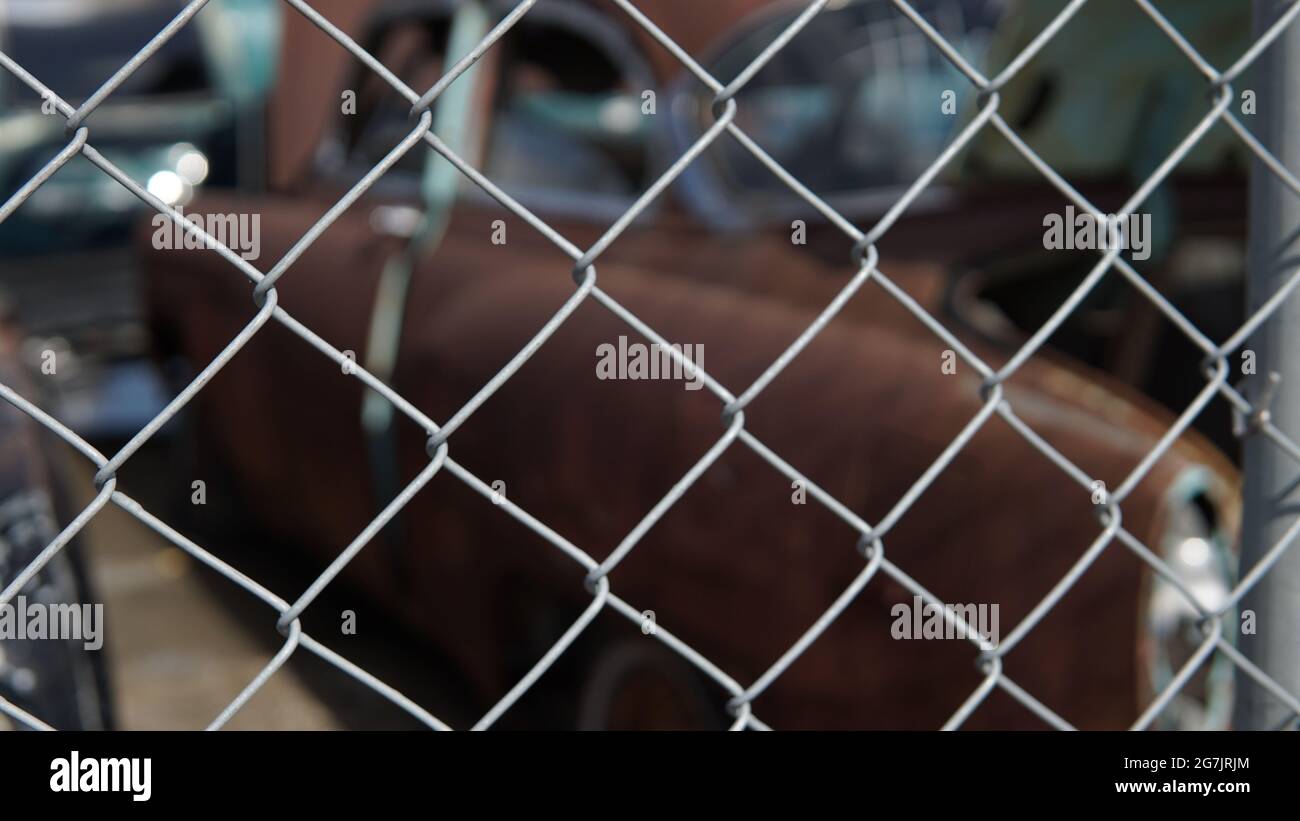 Rusty old car visible through a gate in a junkyard Stock Photo - Alamy