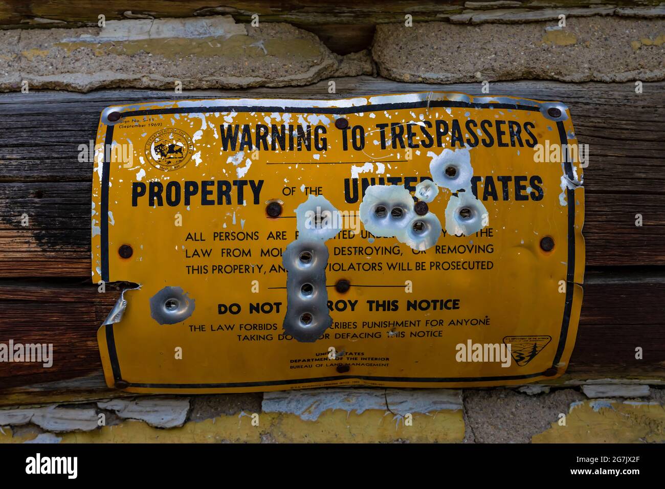 Warning sign, shot up, on fire warden's log cabin near the ghost town ...