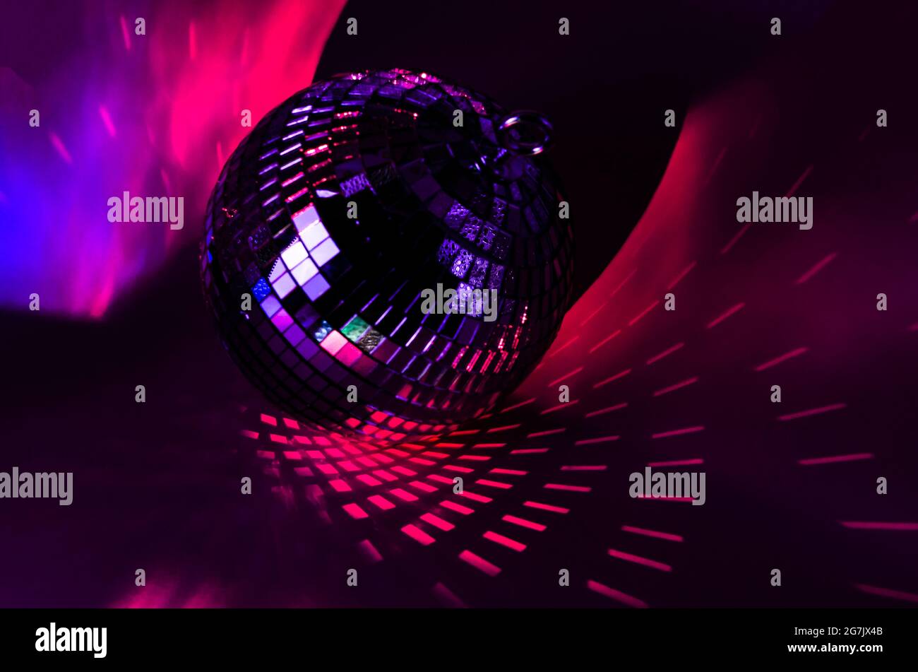 Disco ball shining in red light. party ball Laying in the dark Stock ...