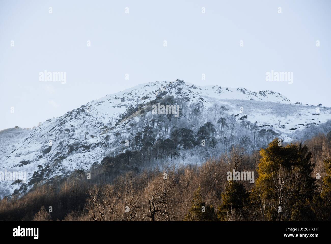 Snow capped mountain with white winter sky Stock Photo - Alamy