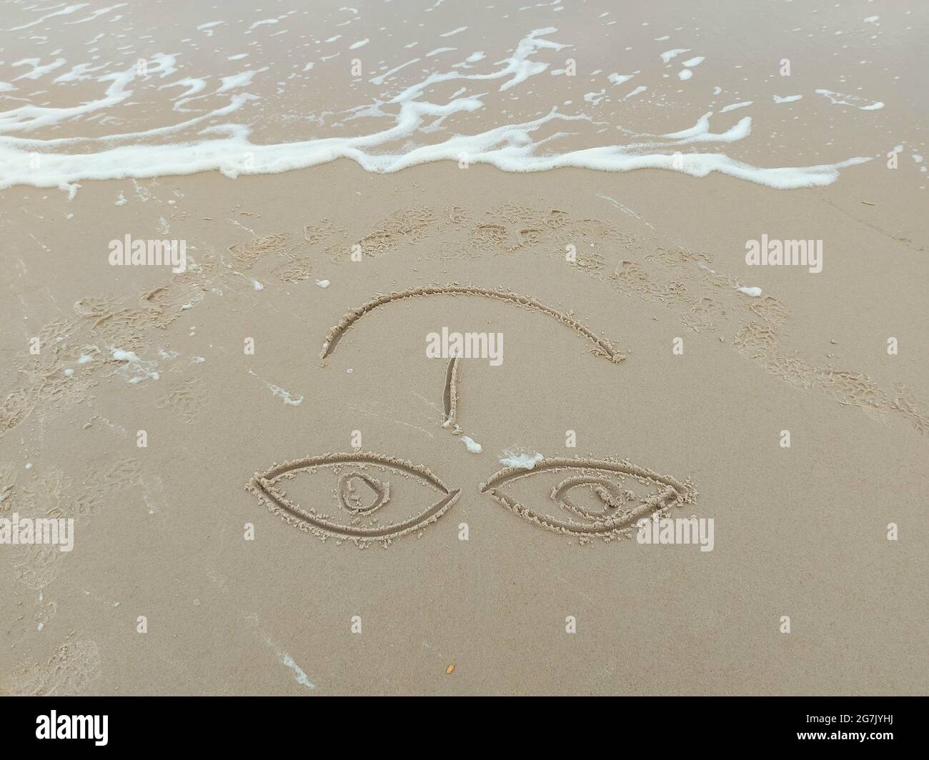 Face outlined in the sand on a beach Stock Photo - Alamy