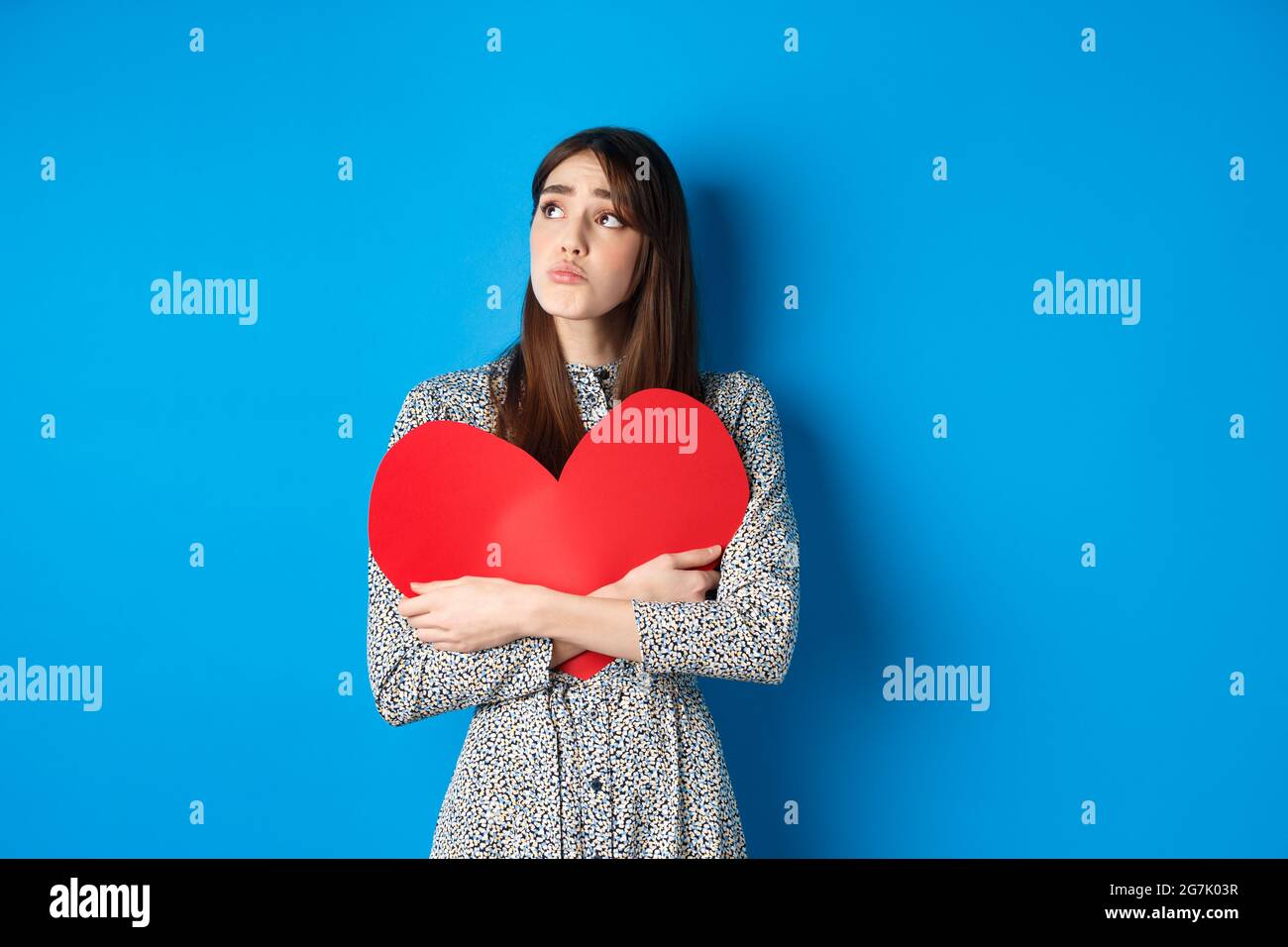 Valentines day. Sad heartbroken girl sobbing, looking aside at empty ...