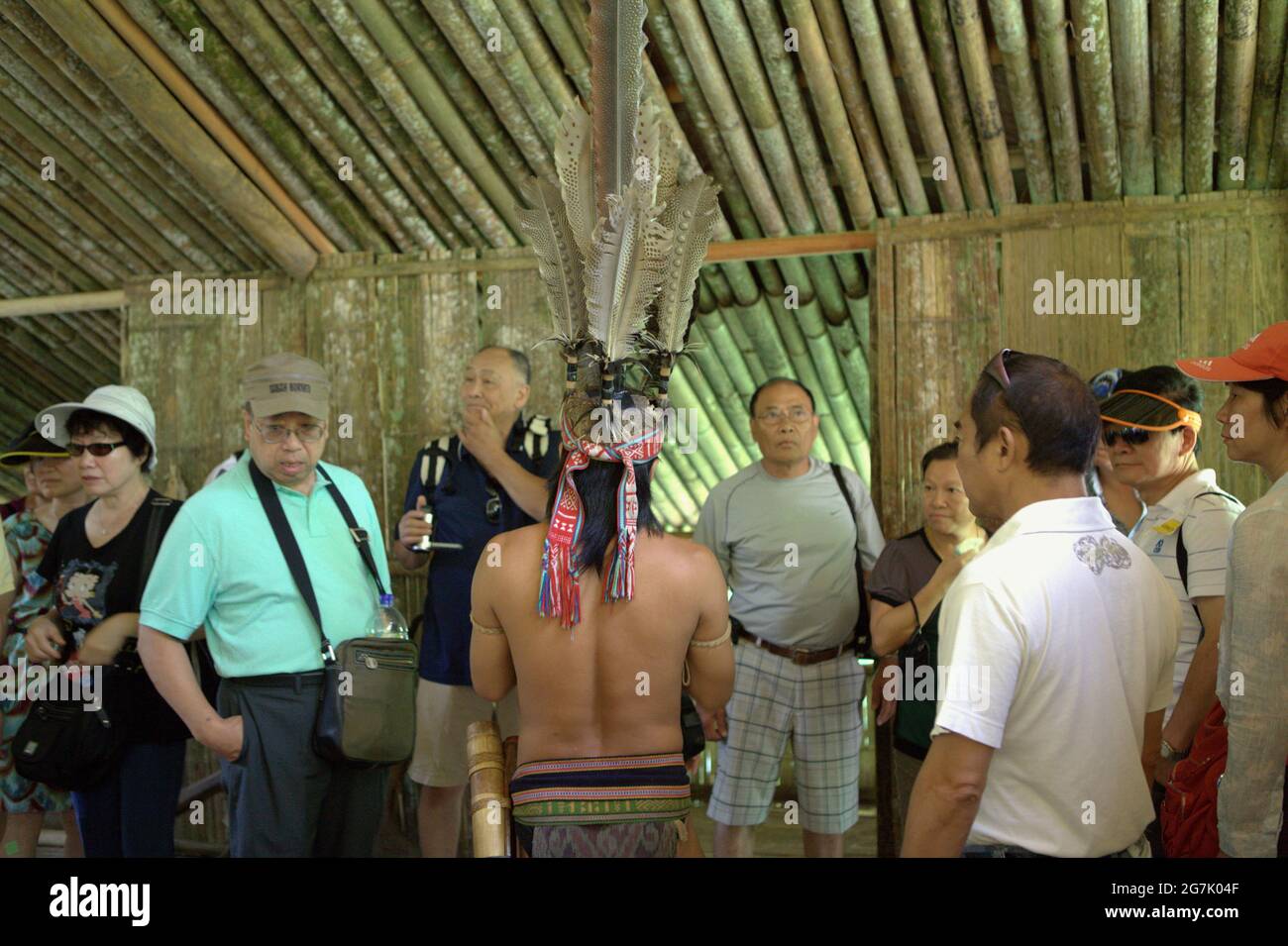 A tourism worker wearing indigenous attire is giving explanations to ...