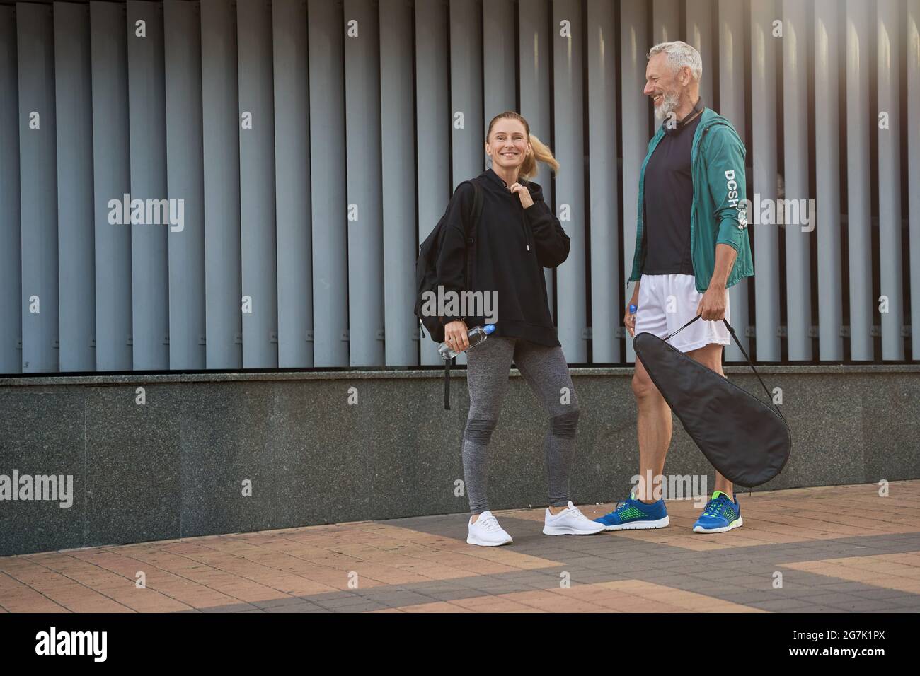 Sportive middle aged man and woman in sportswear looking cheerful ...