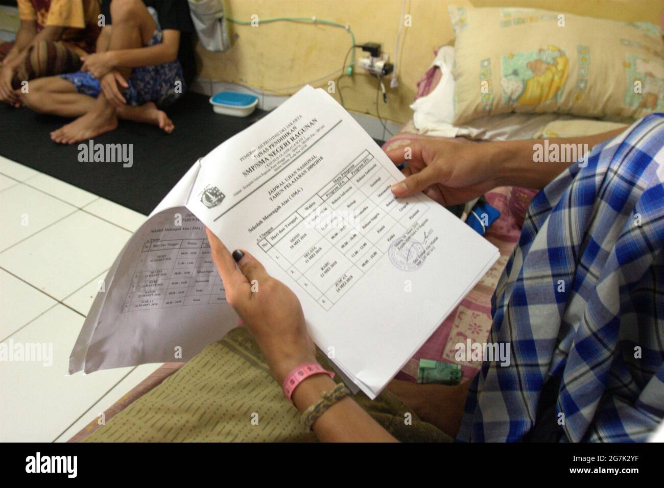 A young badminton athlete reading school exams schedules printed on a ...