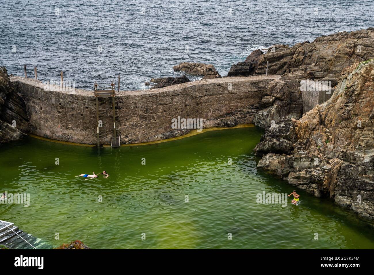 People enjoy swimming in a natural saltwater pool during a summer day ...
