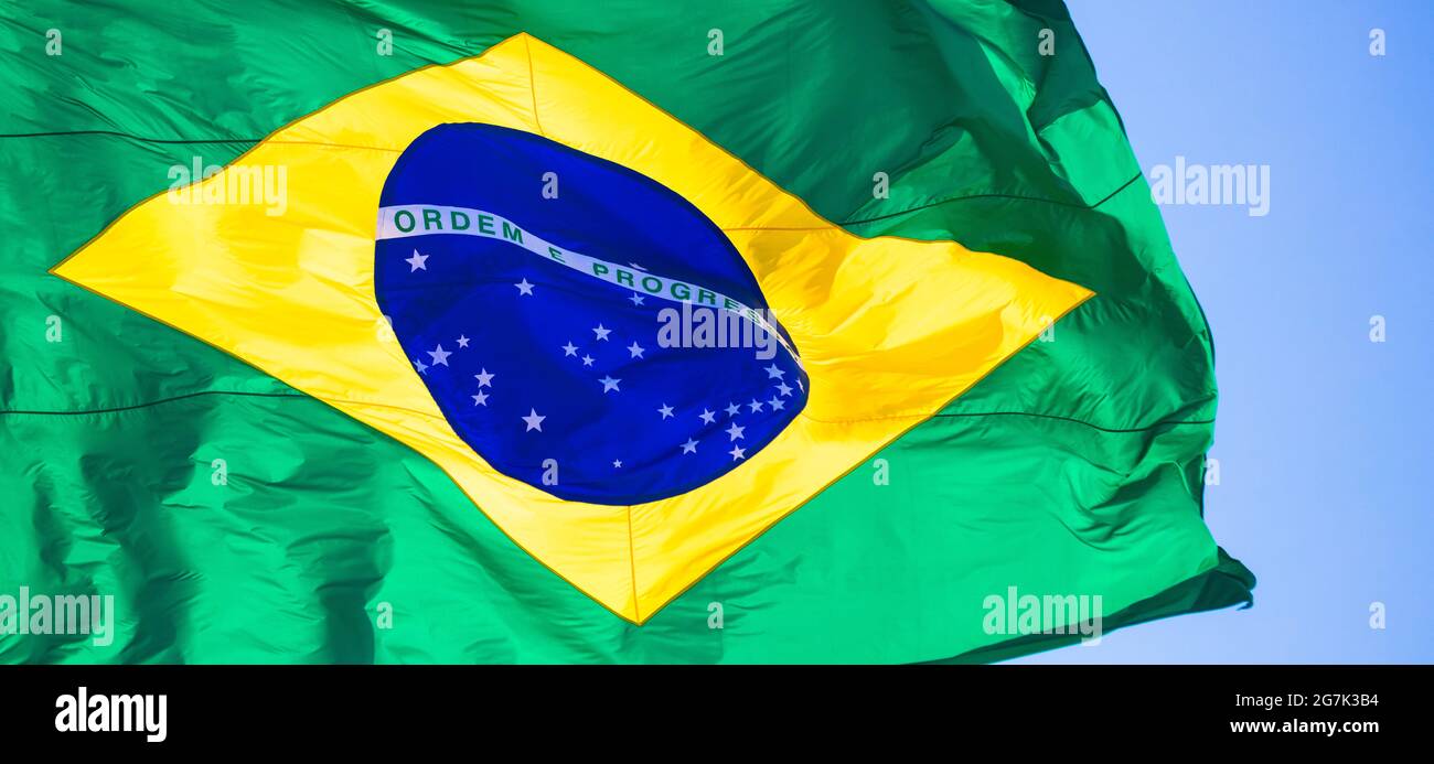 Image of the flag of Brazil waving in the blue sky from the wind Stock ...