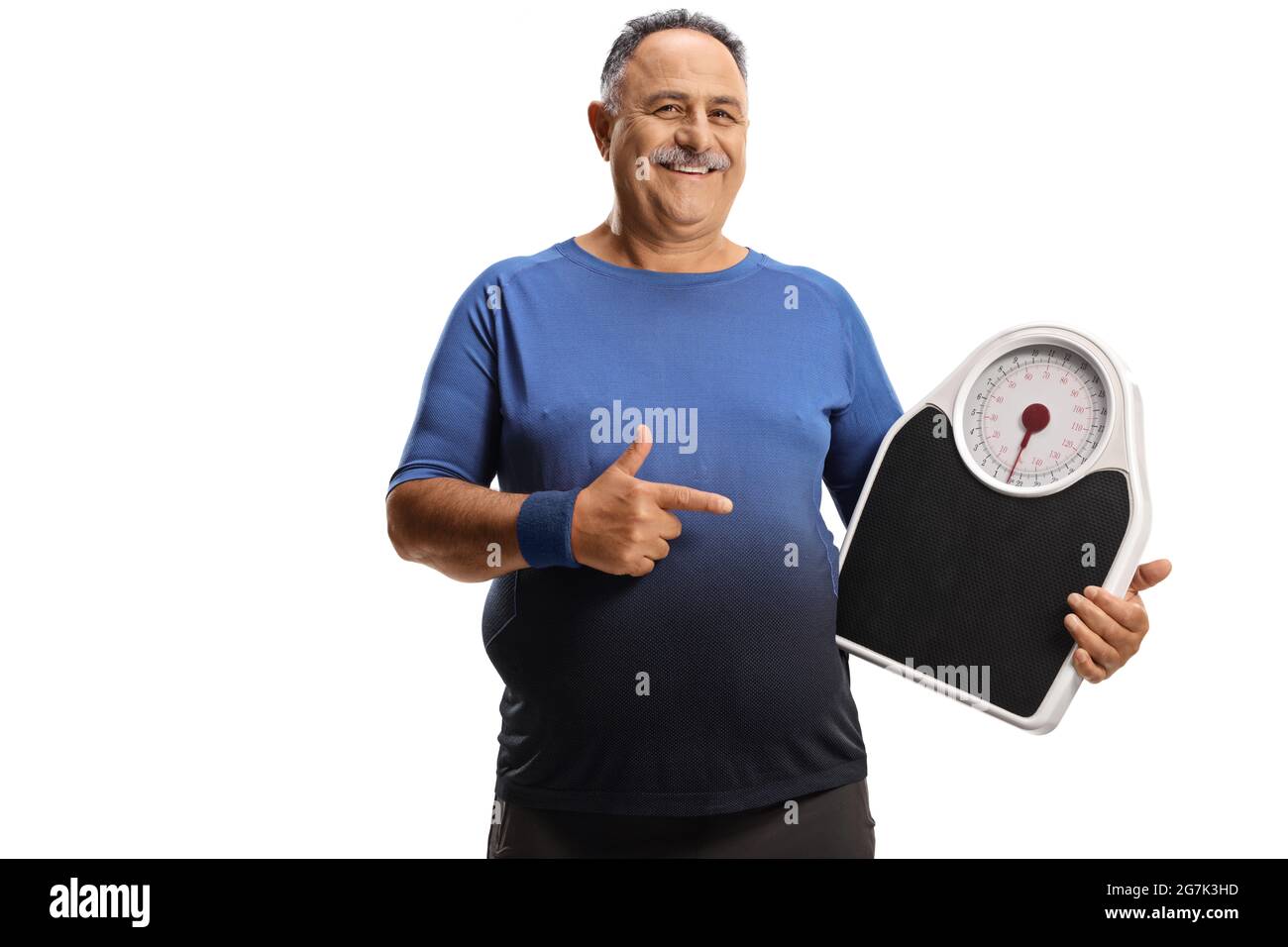 Mature man in sportswear holding a weight scale and pointing isolated ...
