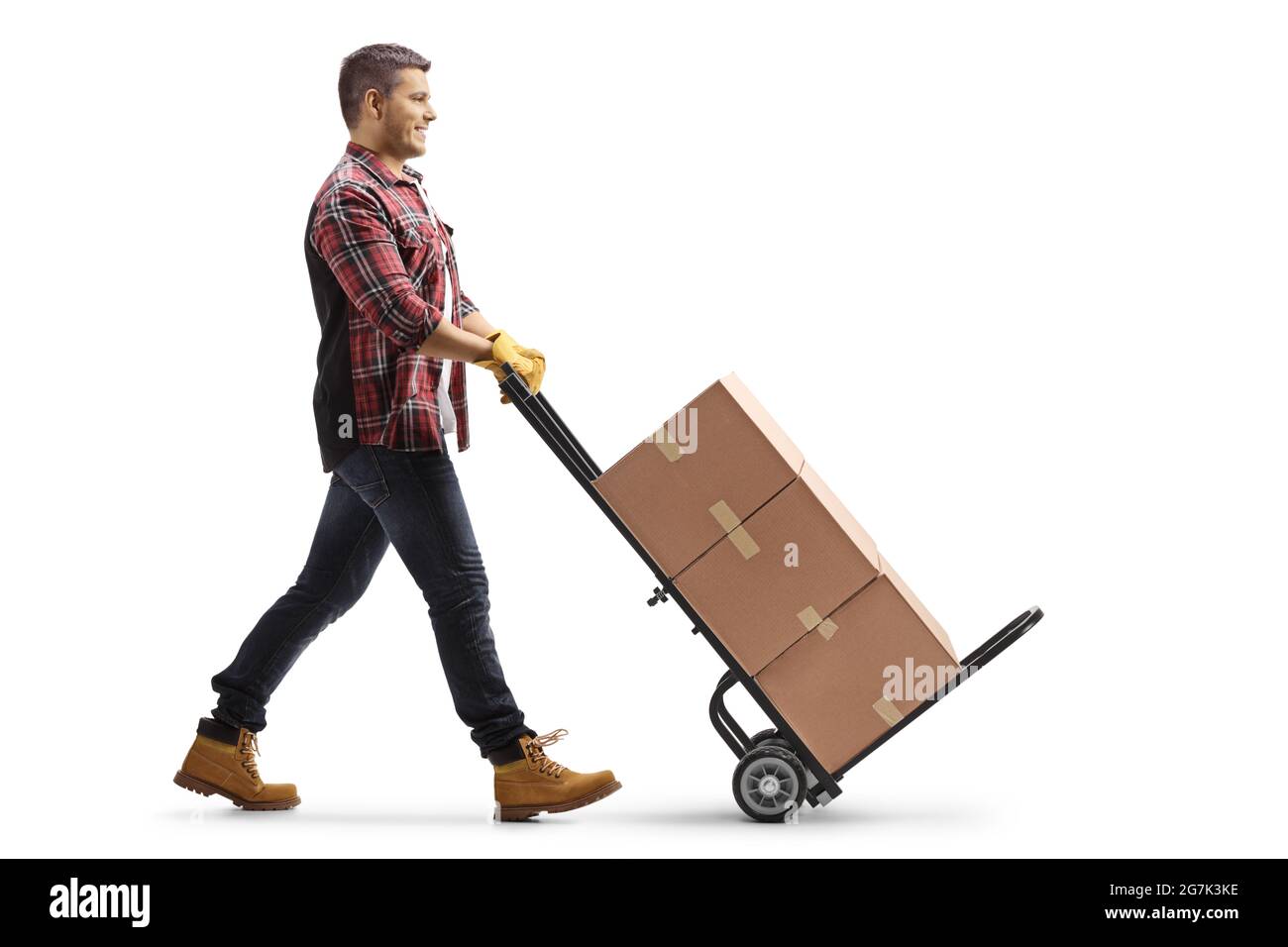 Full length profile shot of a man pushing a hand truck with cardboard ...