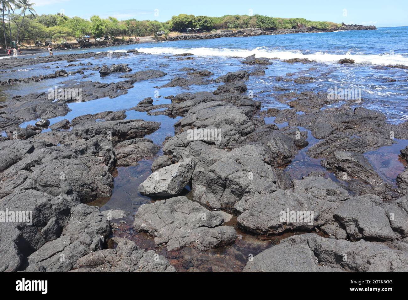 Oceanside landscape of black volcanic rock with waves in a cove along ...