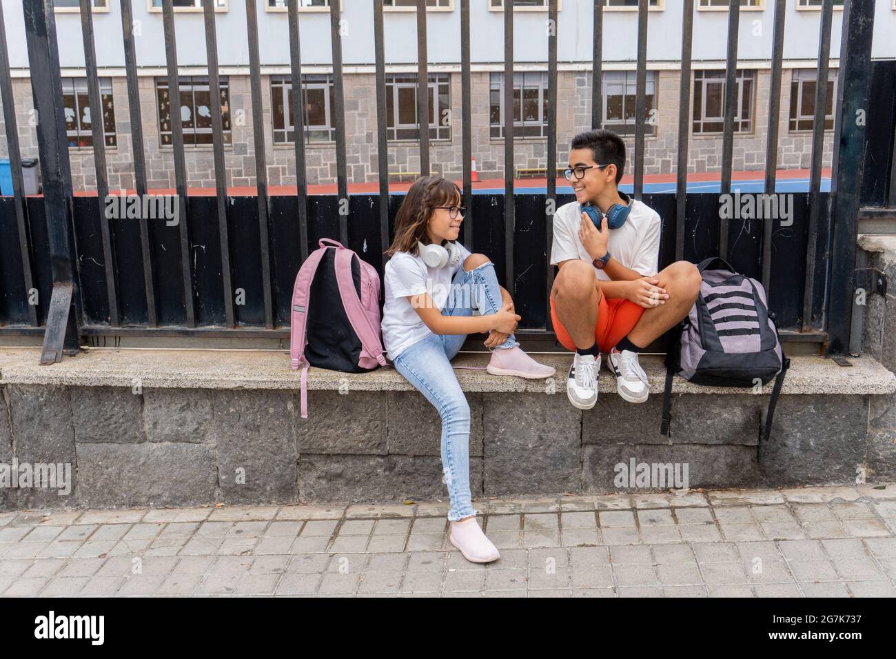 Two Caucasian boys laughing and talking at the school gate. Back to ...