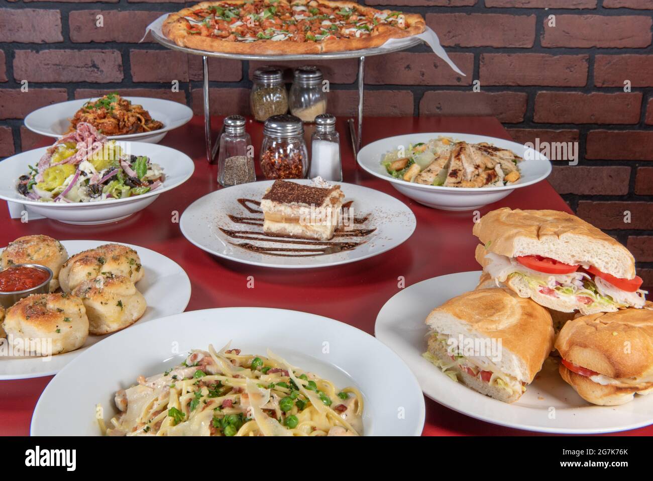 Pizzaria feast of a full table of food consisting of pizza, pasta ...