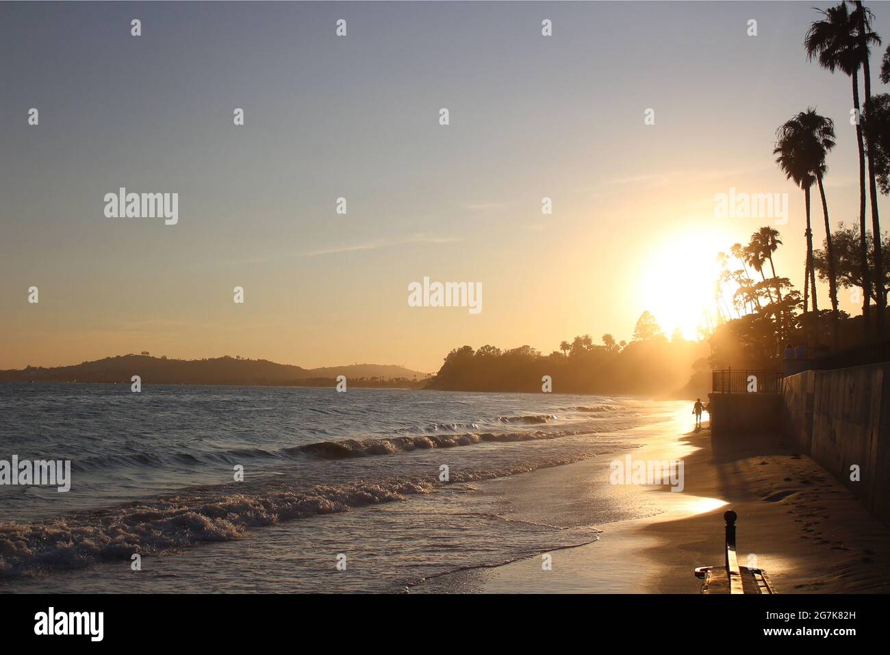 Butterfly Beach sunset behind the palm trees Stock Photo - Alamy
