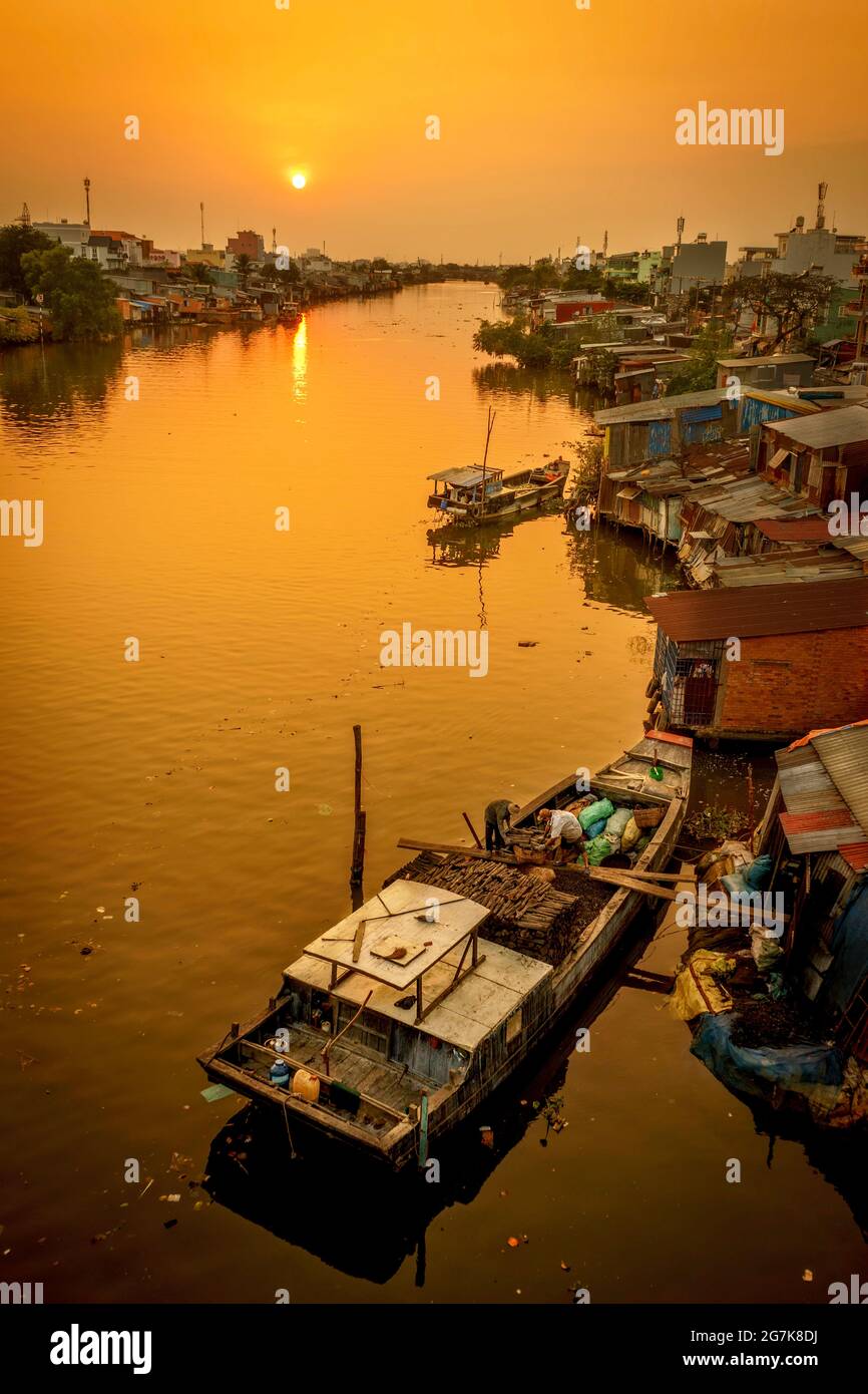 Sunset on the river with slums on both sides Stock Photo - Alamy