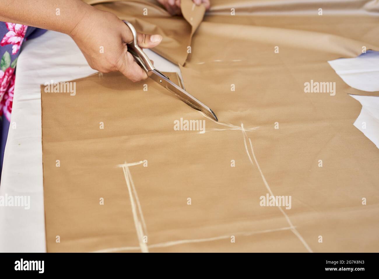 Dressmaker cutting cloth with scissors in a tailor studio Stock Photo ...