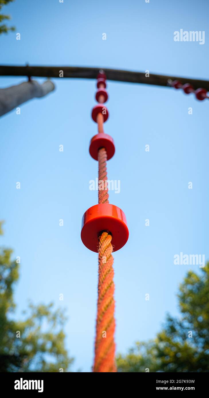 Vertical shot of a climbing rope under a blue sky at the playground ...