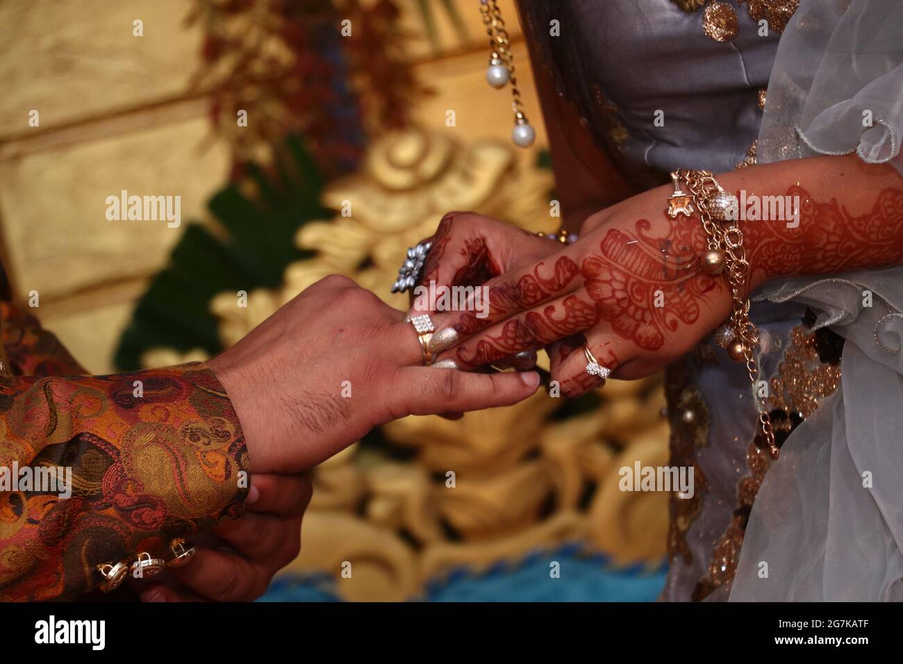 Close up of an Indian couple exchanging wedding rings during rings ...