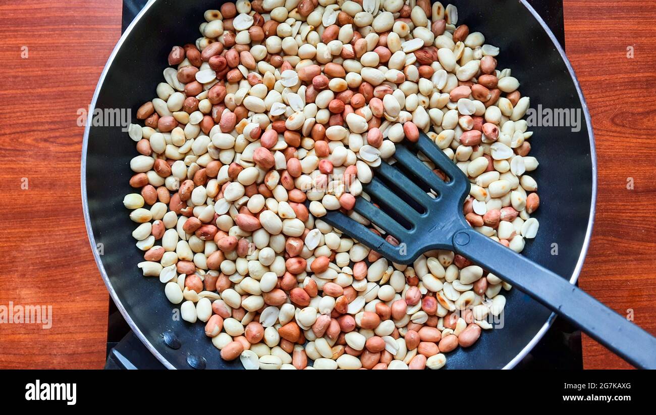Top view of roasting peanuts in a frying pan on a induction cookware ...