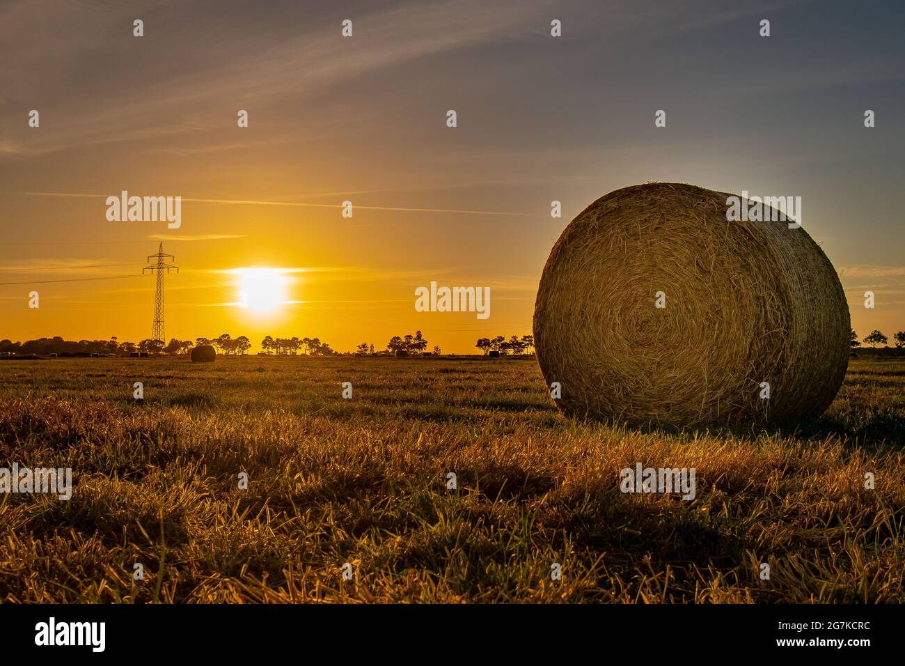 Hay bale in a field during sunset Stock Photo - Alamy