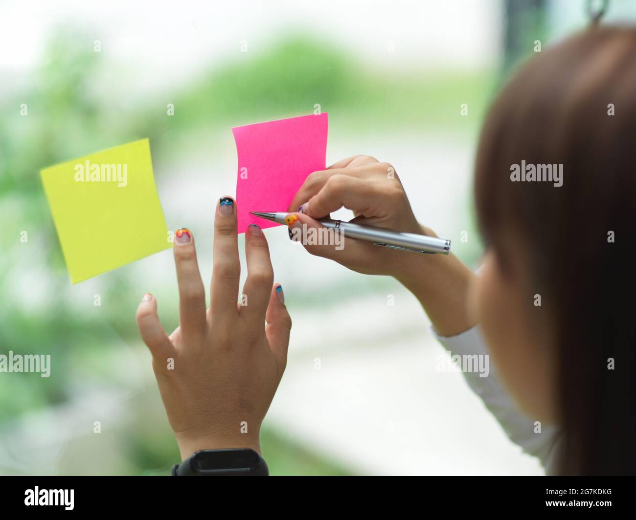 Colleagues writing sticky notes wall hi-res stock photography and ...