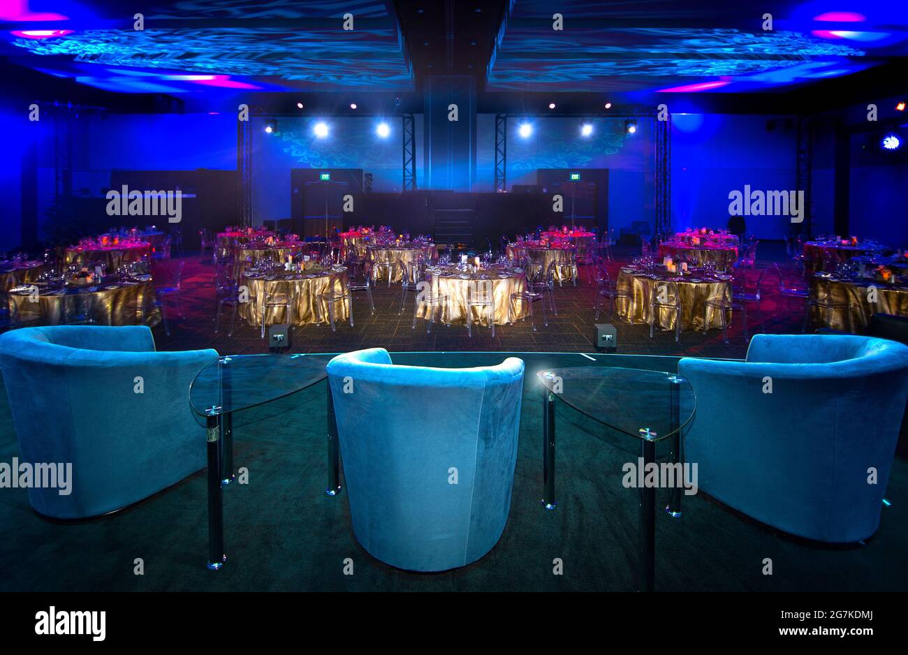 Chairs are set up on a stage facing a banquet hall just before an event ...