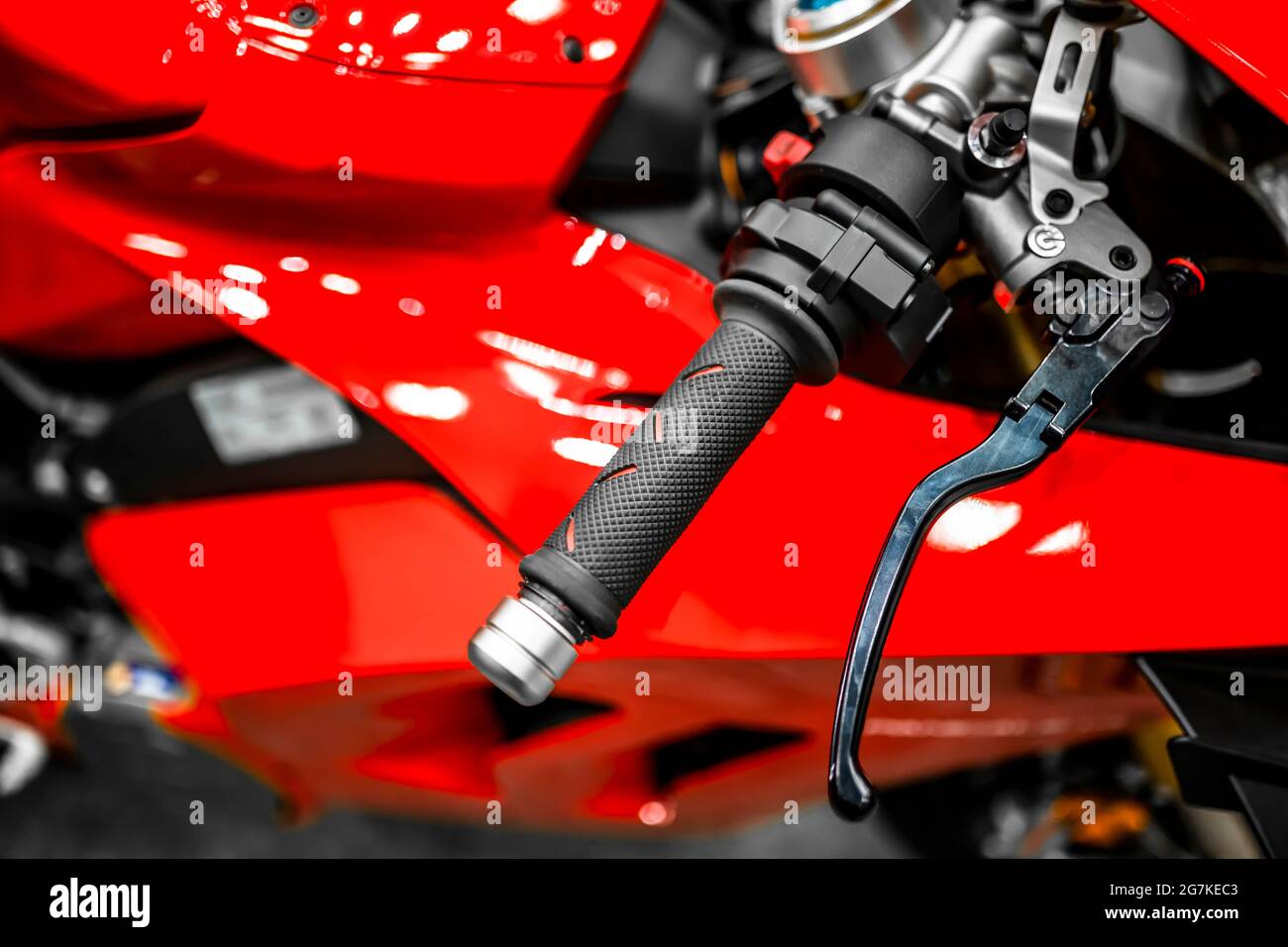 Shiny red sport motorcycle with handlebar controls and aerodynamic body ...