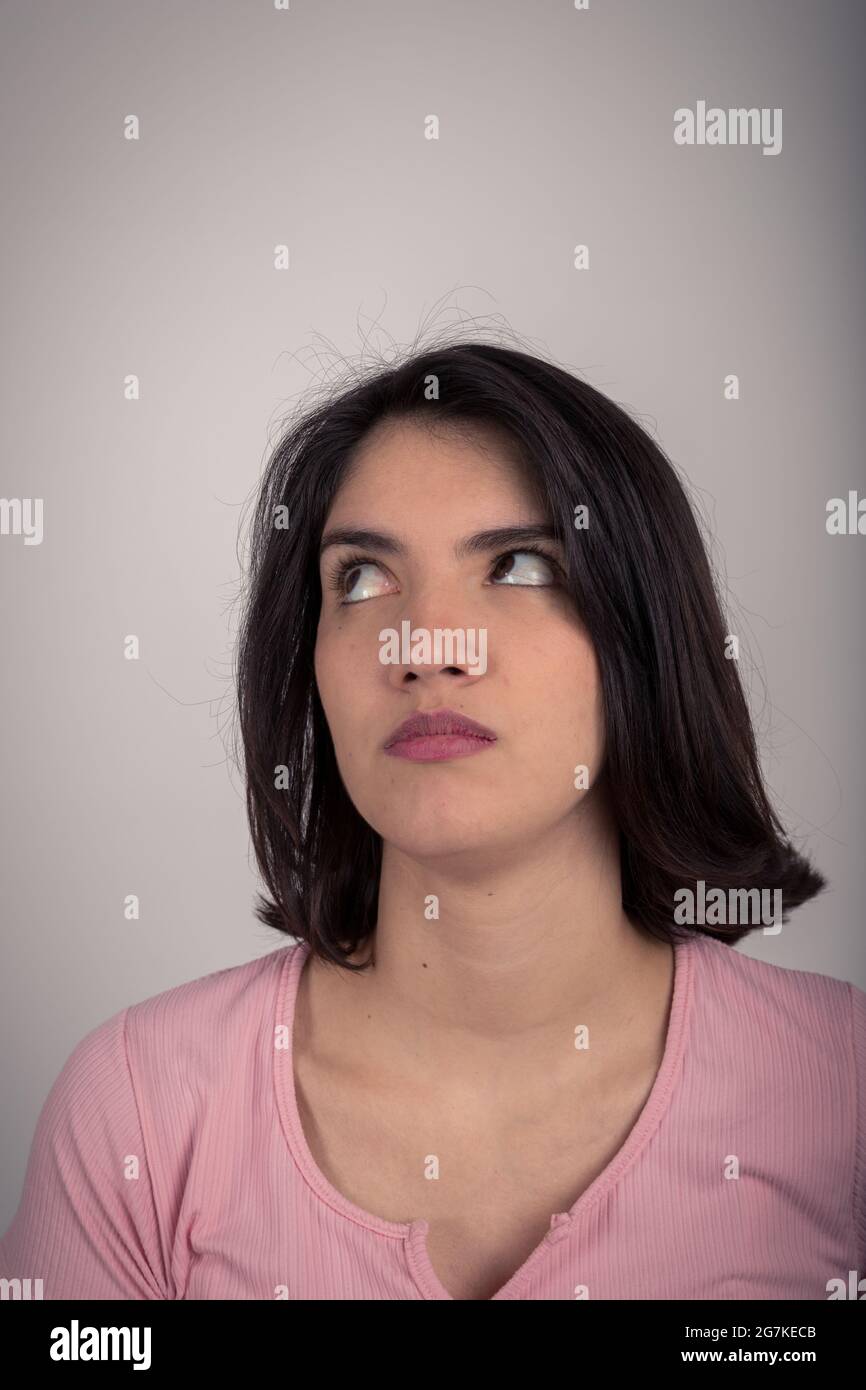 Portrait of a serious female with face upward thinking or wondering on ...
