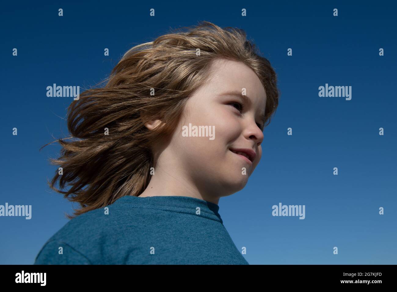 Kids looking away, close up head of cute child on blue sky with copy ...