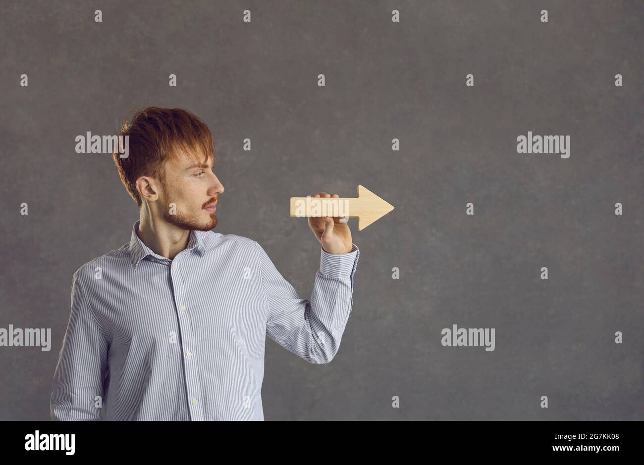 Confident serious young businessman freelancer hold arrow with right ...