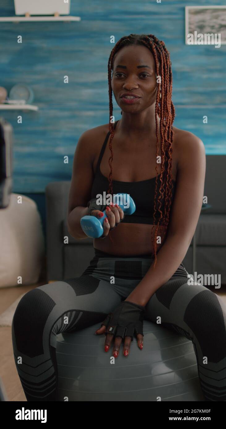 Athletic woman trainer stretching body muscles recording morning yoga ...