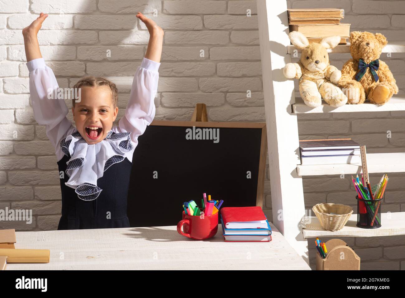 Excited school girl in classroom at school. Amazed kids education and ...