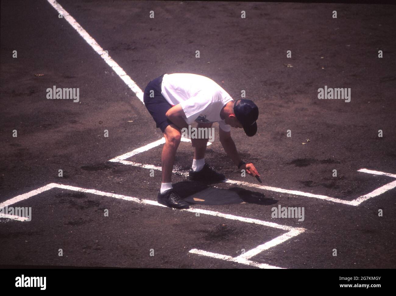 TOKYO, JAPAN - Jul 02, 2021: Baseball player wipes dust from home plate ...